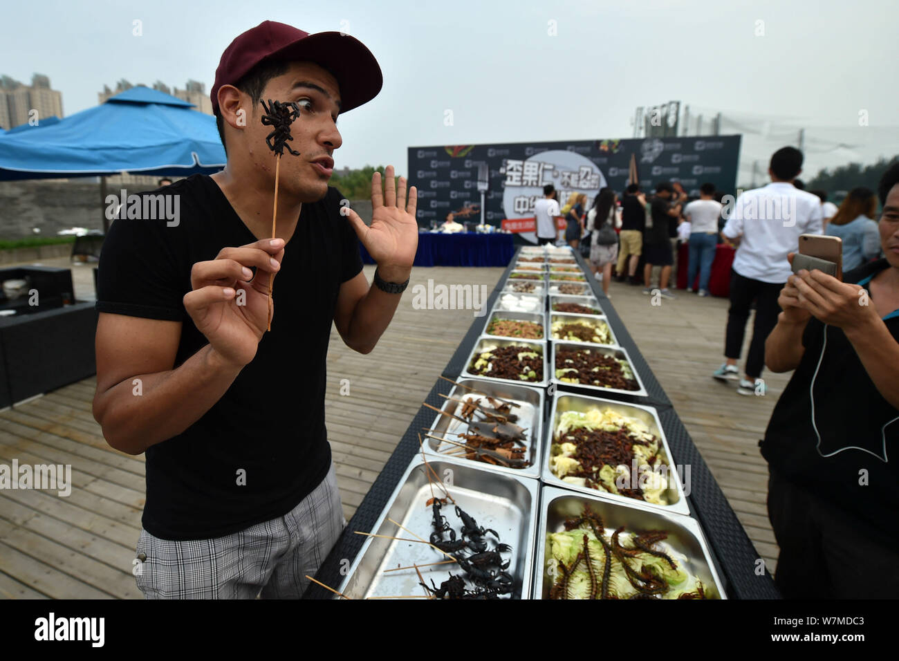 A foreigner tries out a fried spider during a challenge to eat weird ...