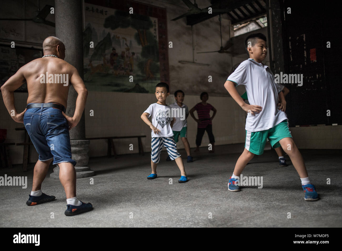 Chinese elementary schoolboys practice martial arts moves with kungfu ...