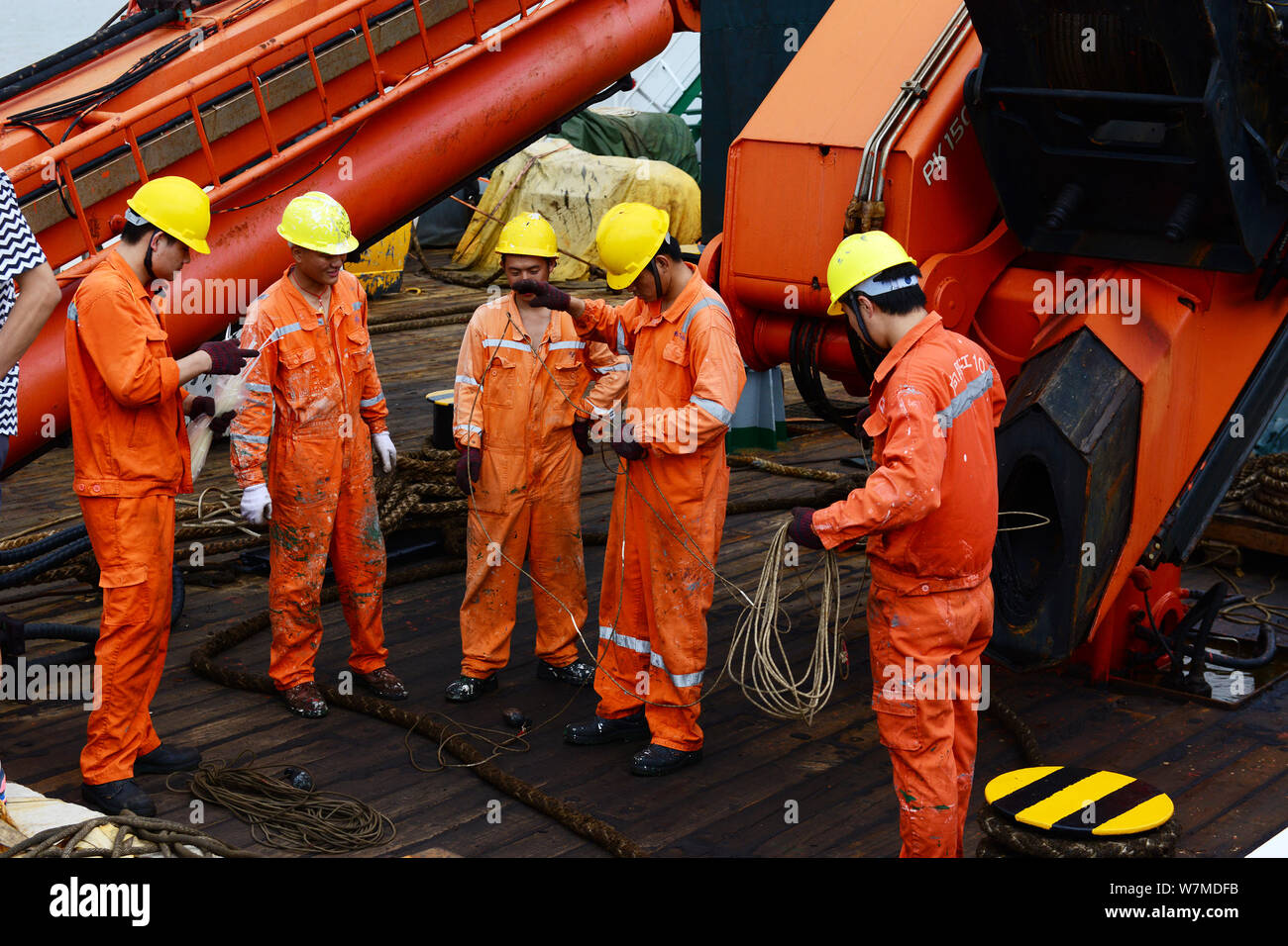 Chinese workers labor at Chinese oceanographic ship "Xiangyanghong 10 ...