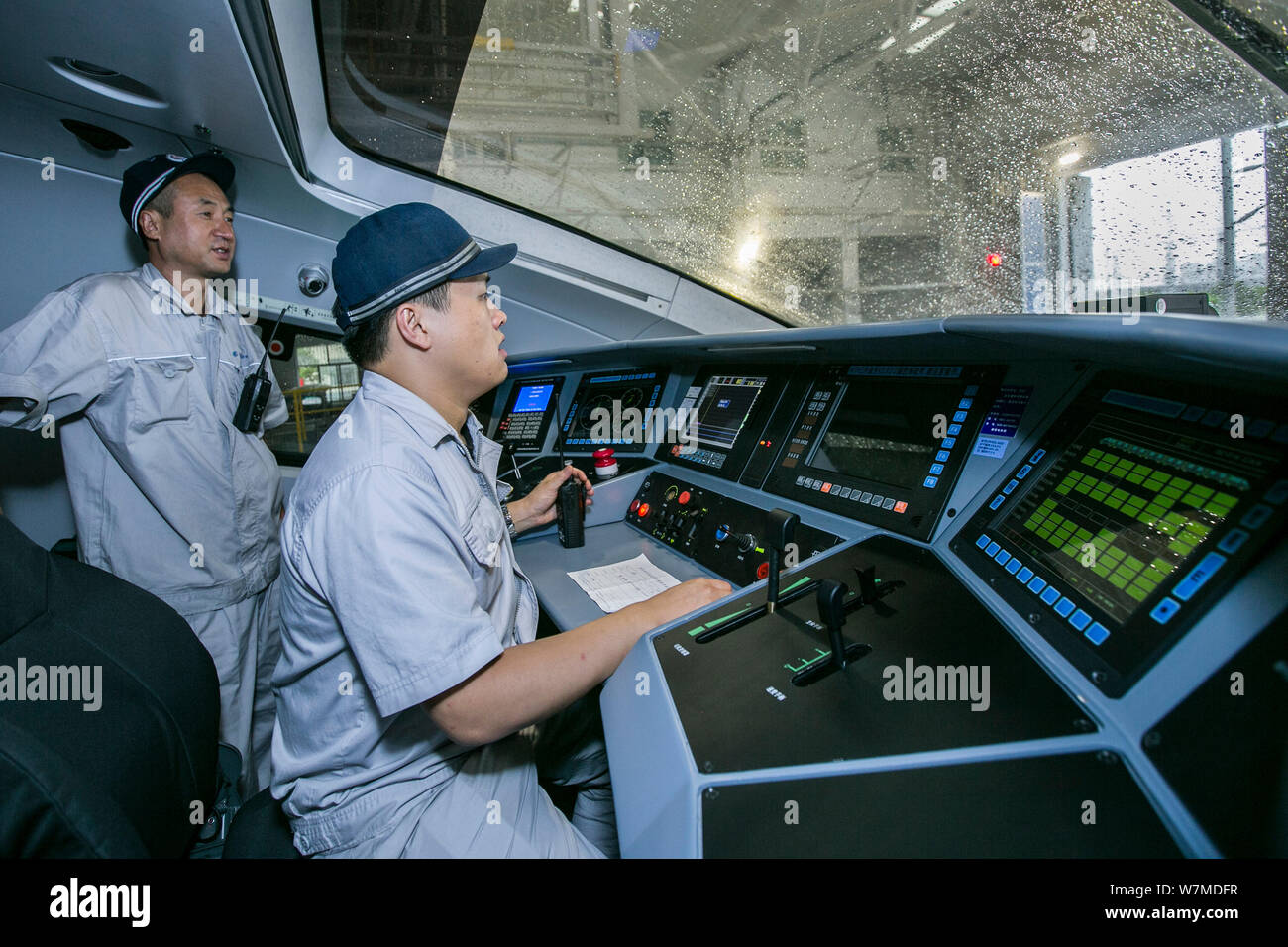 Chinese workers check a CRH5G (China Railway High-speed) bullet train ...
