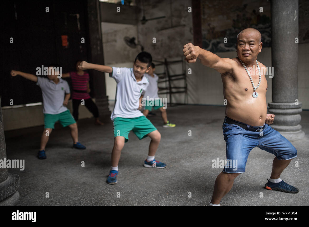 Chinese elementary schoolboys practice martial arts moves with kungfu ...