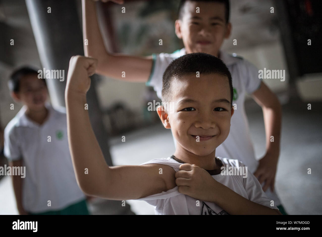 Chinese elementary schoolboys shows their muscles as they practice ...