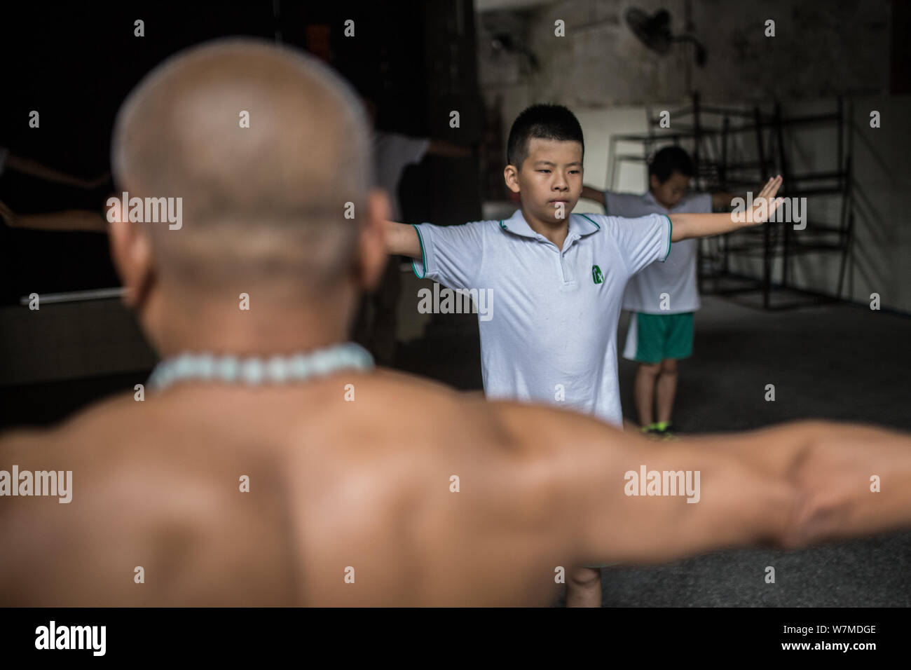 Chinese elementary schoolboys practice martial arts moves with kungfu ...