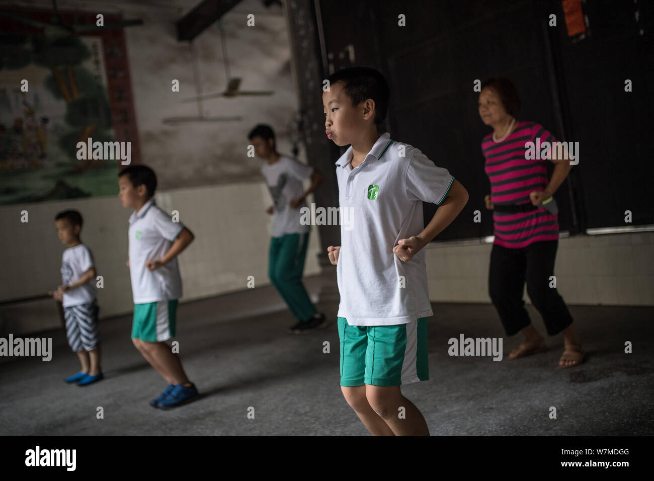 Chinese elementary schoolboys practice martial arts moves with kungfu ...