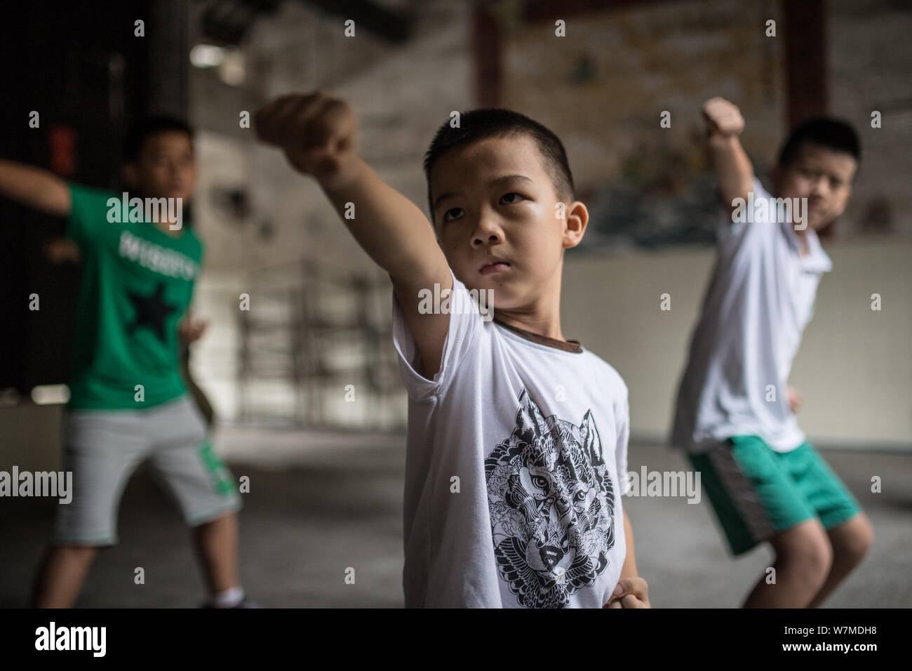 Chinese elementary schoolboys practice martial arts moves with kungfu ...