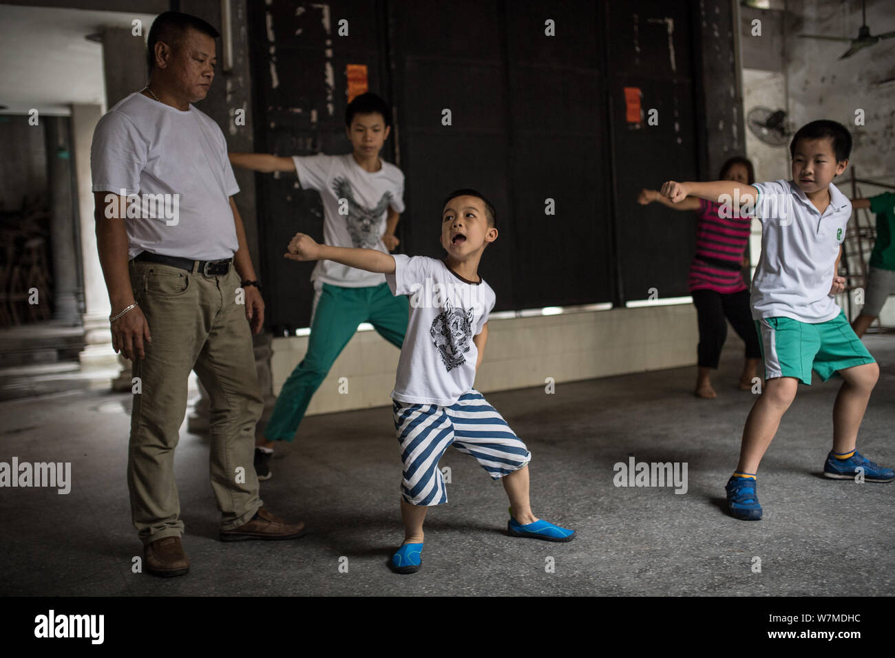 Chinese elementary schoolboys practice martial arts moves with kungfu ...