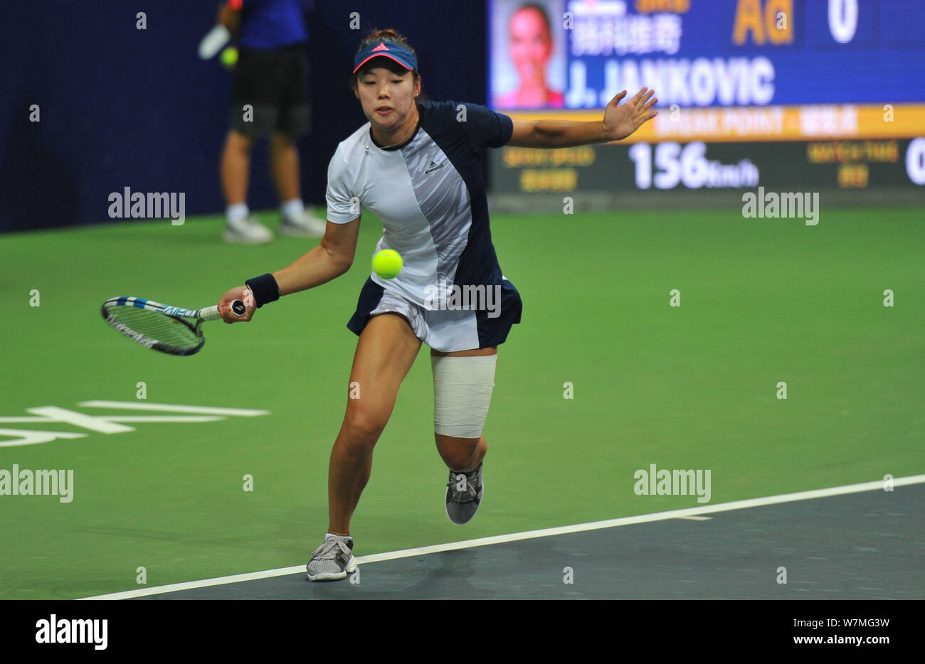 Kang Jiaqi of China returns a shot to Jelena Jankovic of Serbia in their women's singles first ...