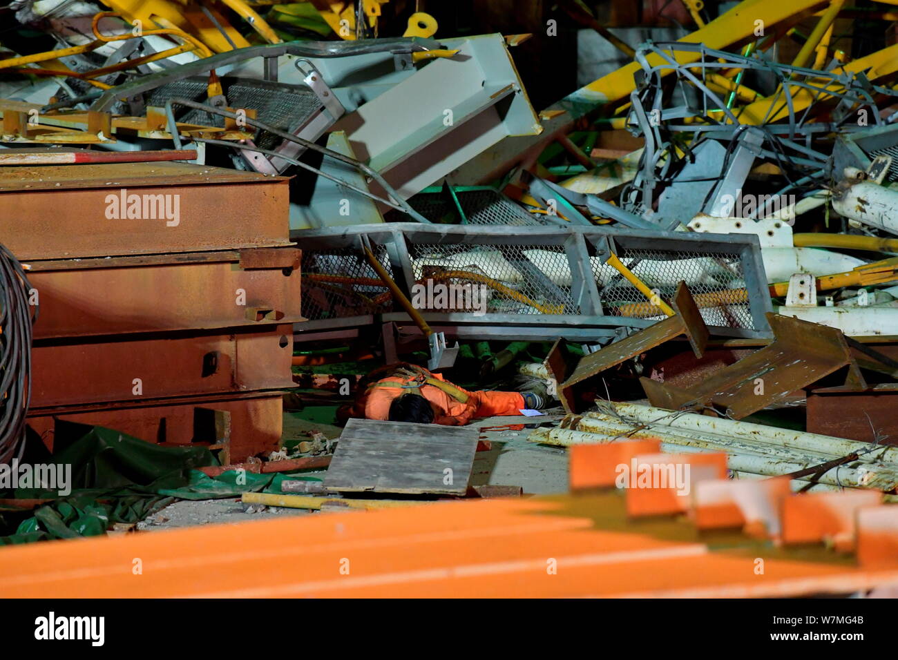 The deformed steel structure of a collapsed tower crane is seen at a ...