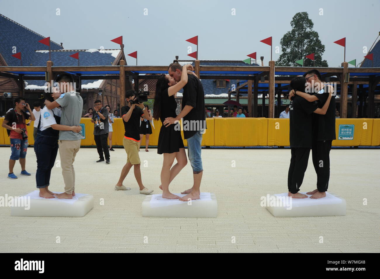 Lovers standing in an ice block kiss each other during a kissing ...