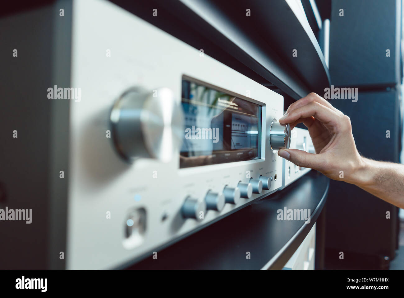 Hand of woman turning up volume of Hi-Fi amplifier Stock Photo - Alamy