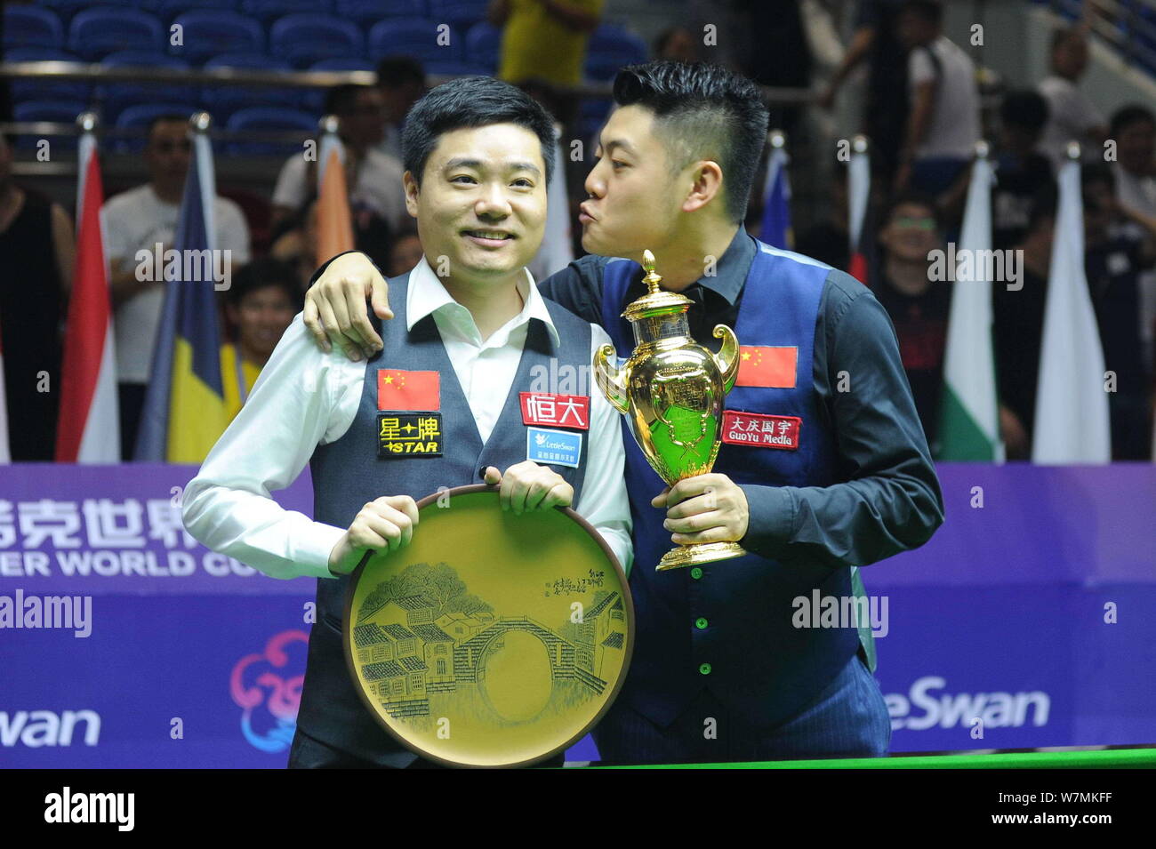 Liang Wenbo, right, kisses Ding Junhui of China A as they pose with their trophies at the award ...