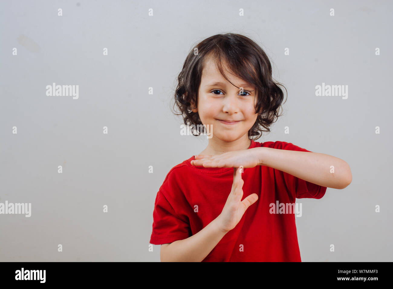 Smiling little boy making a pause or break time hand gesture Stock ...