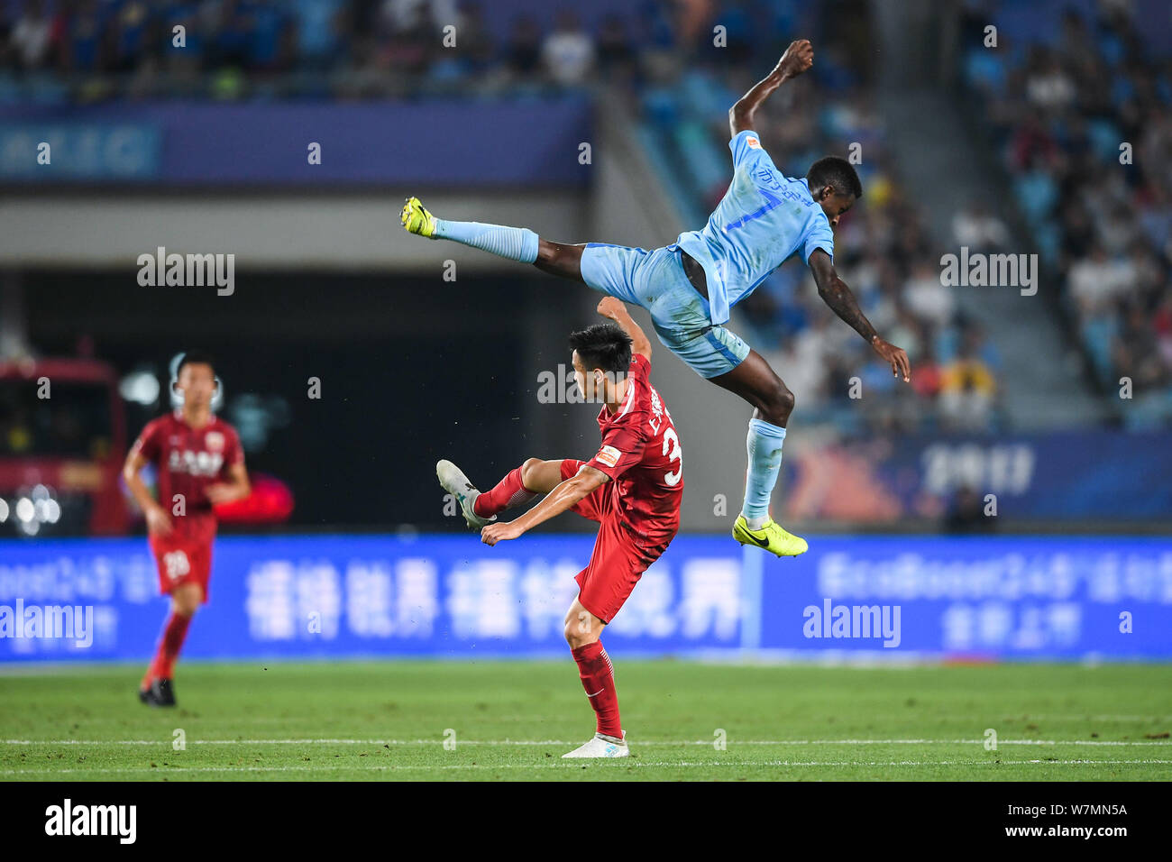 Brazilian football player Ramires, upper, of Jiangsu Suning, challenges ...