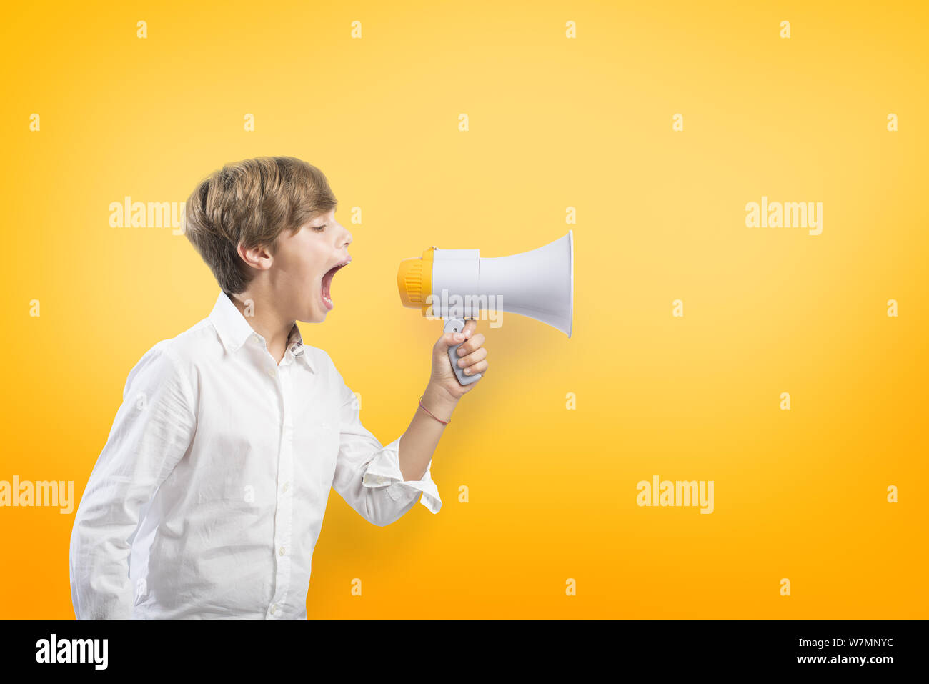 Child screaming on the megaphone on yellow background Stock Photo - Alamy