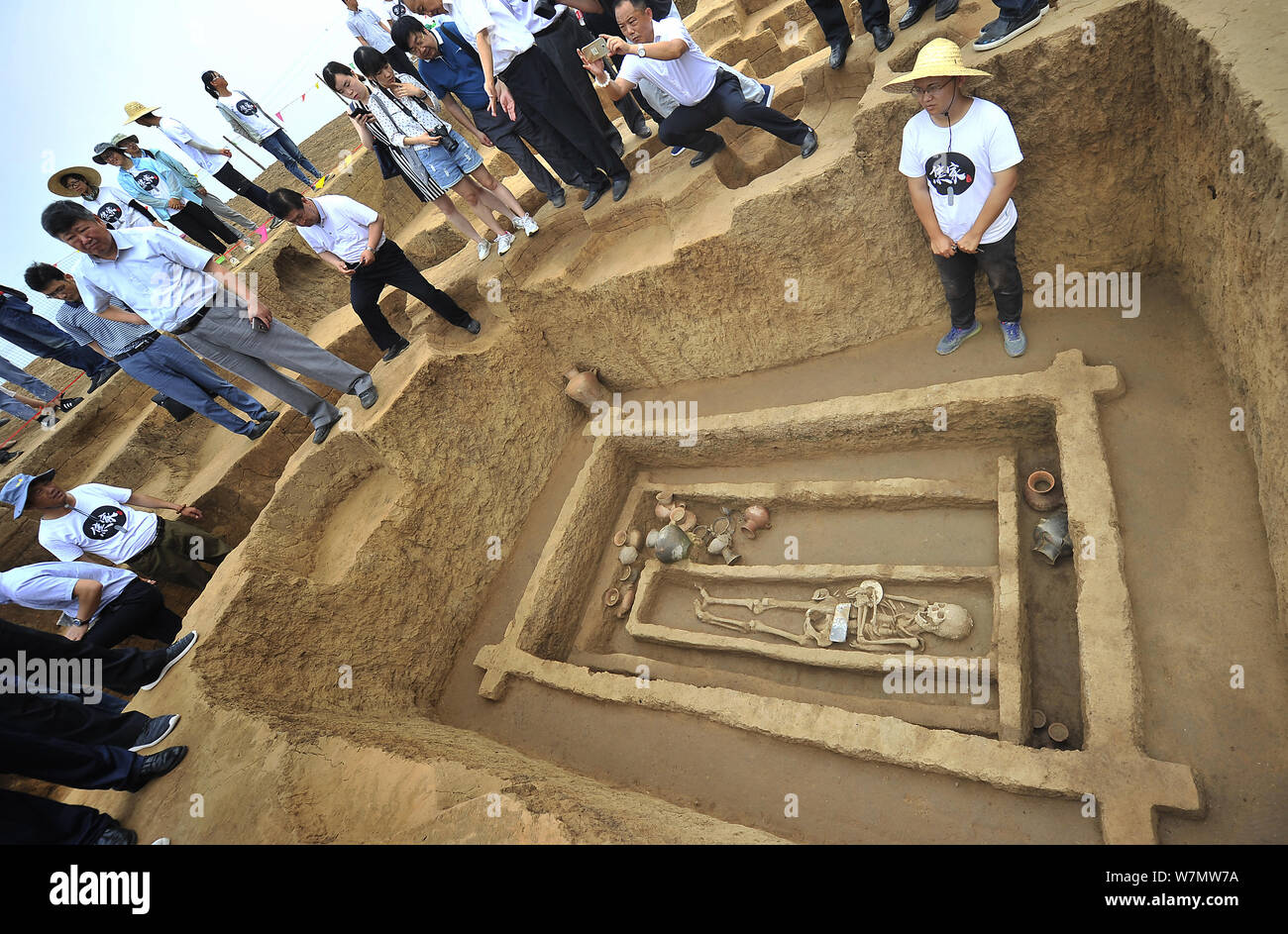 --FILE--Chinese archaeologists look at a skeleton reaching 1.9 meters ...