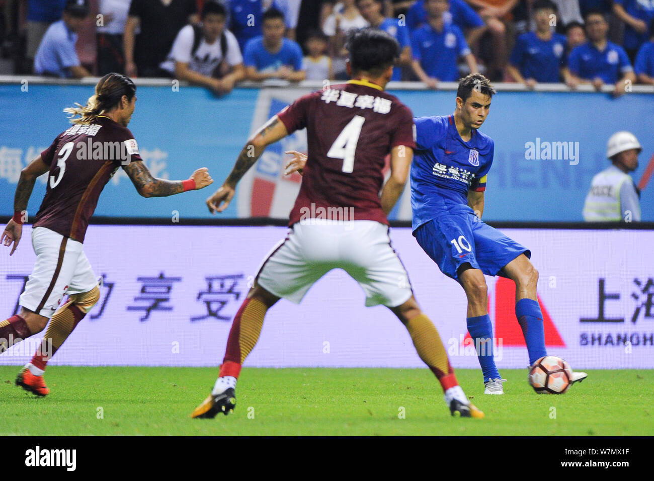 Colombian football player Giovanni Moreno, right, of Shanghai Greenland Shenhua kicks the ball ...