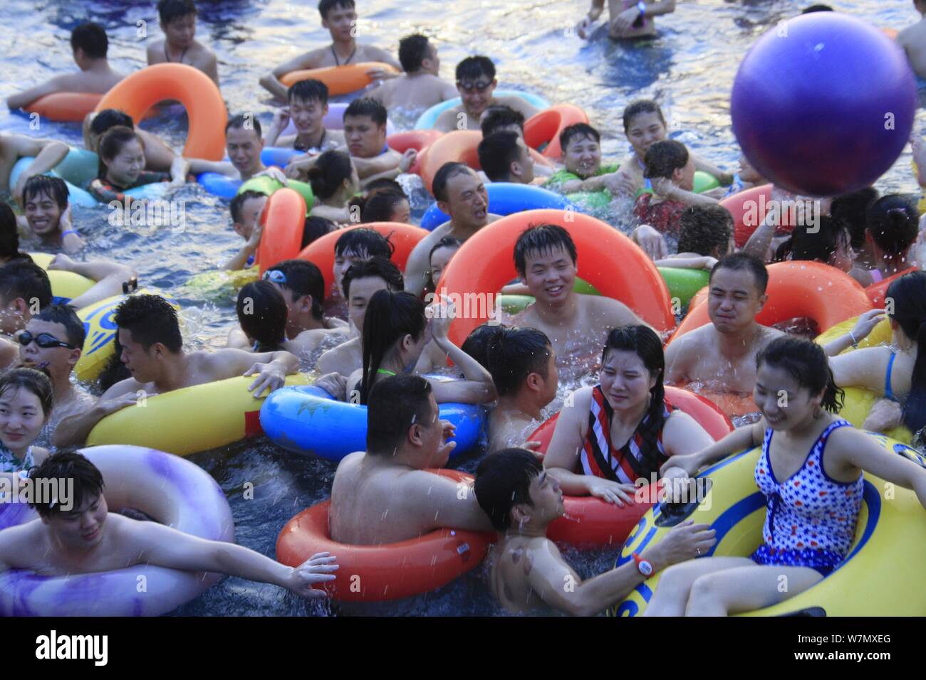 Chinese holidaymakers crowd a swimming pool at a water park in Nanchang ...