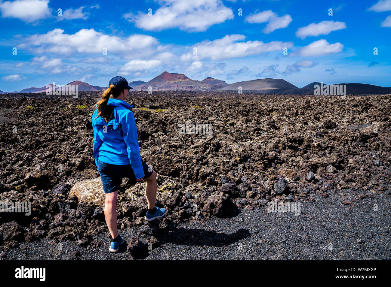 Spain, Lanzarote, Tourist woman standing at scenic edge of dry lava ...