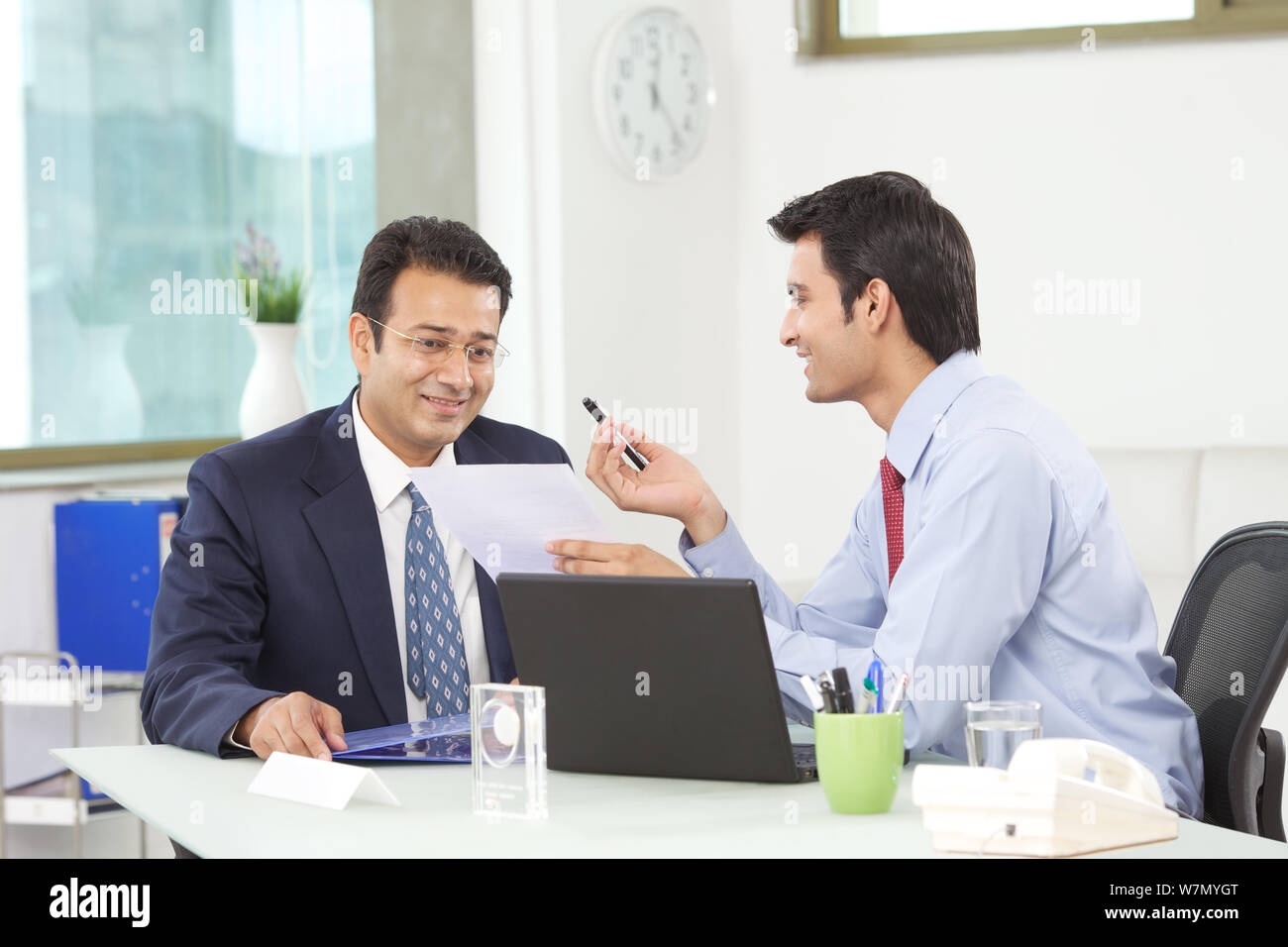 Financial advisor explaining on document to a client Stock Photo - Alamy