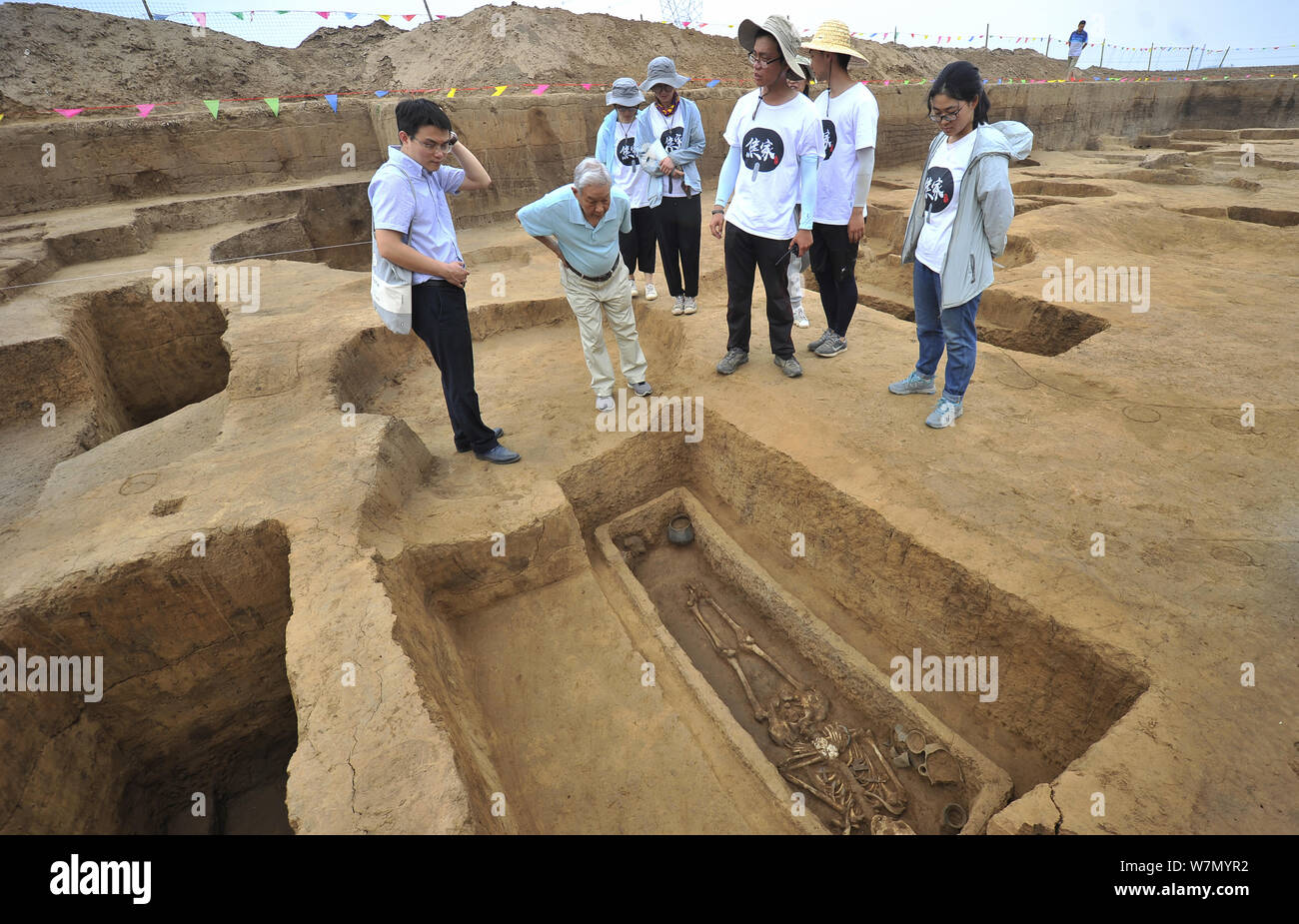 --FILE--Chinese archaeologists look at a skeleton reaching 1.9 meters ...