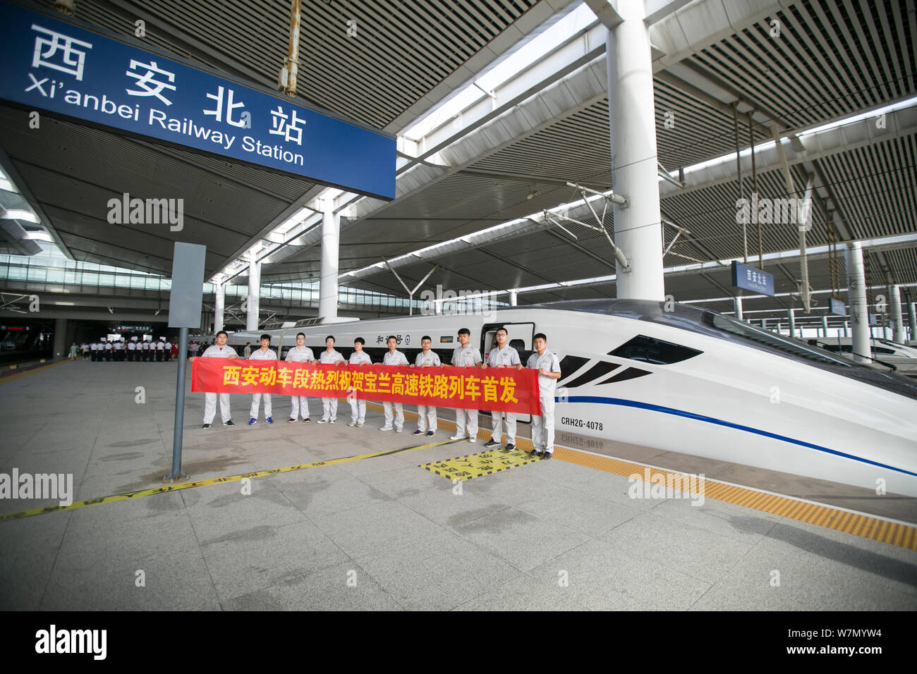 Chinese workers pose in front of the new bullet train on the Baoji ...
