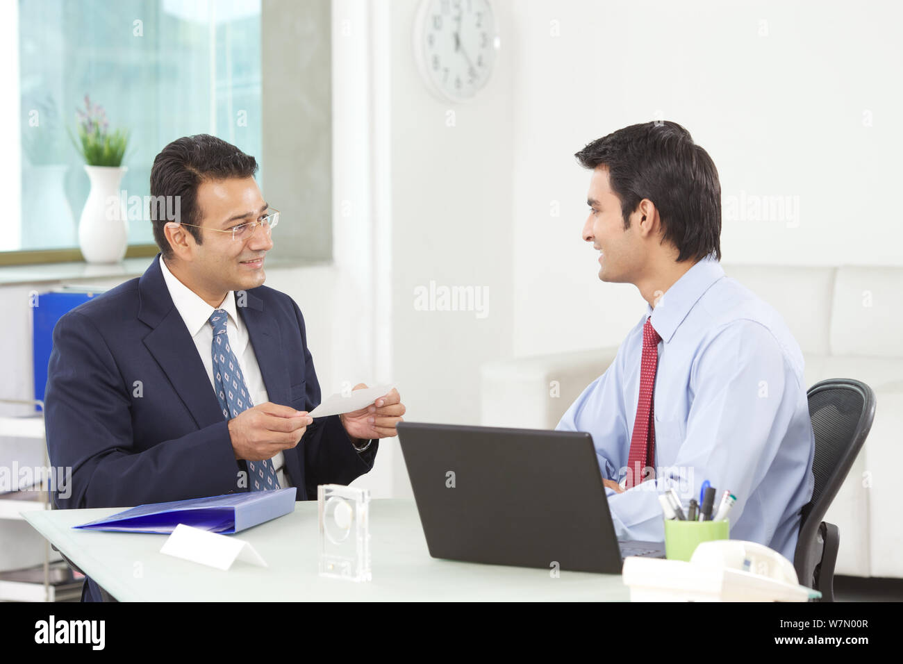 Client looking at cheque given by bank manager Stock Photo - Alamy