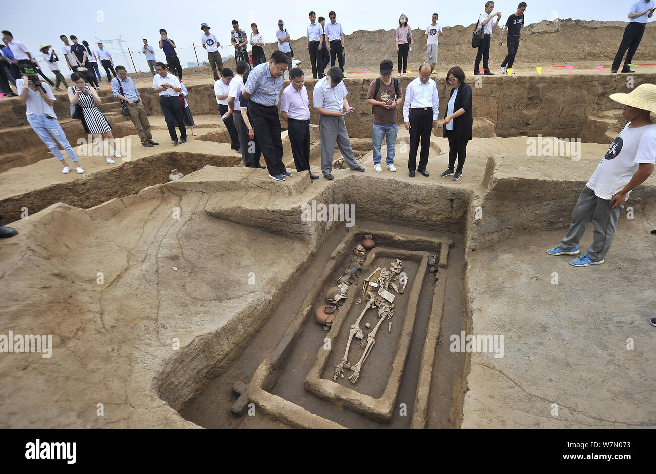 --FILE--Chinese archaeologists look at a skeleton reaching 1.9 meters ...