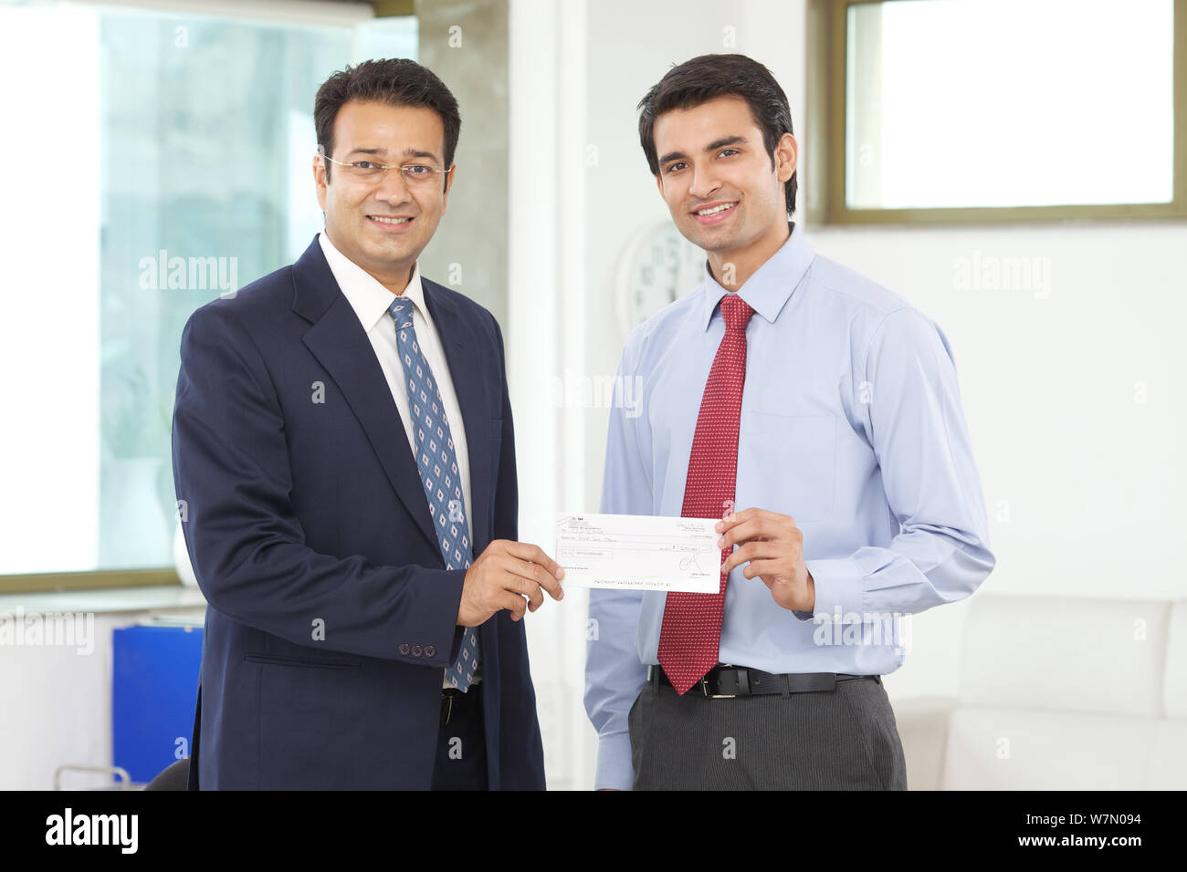 Businessman giving salary cheque to his employee Stock Photo - Alamy