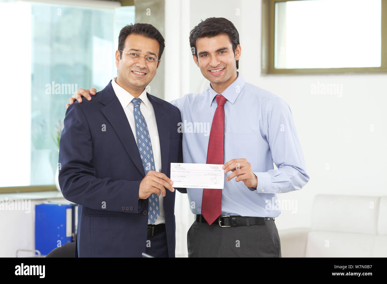 Businessman giving salary cheque to his employee Stock Photo - Alamy
