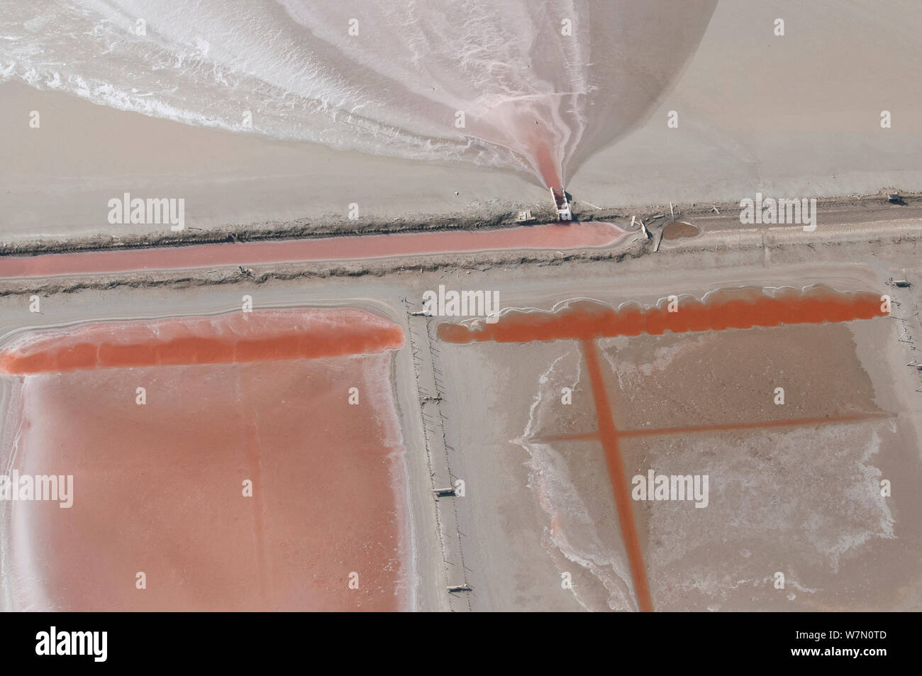 Aerial view of dry salt pan with depression coloured red by Dunaliella ...
