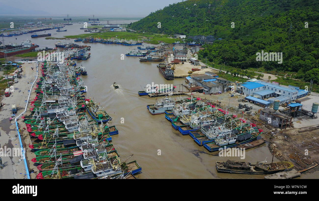 In this aerial view, fishing boats are docked at a harbor in ...