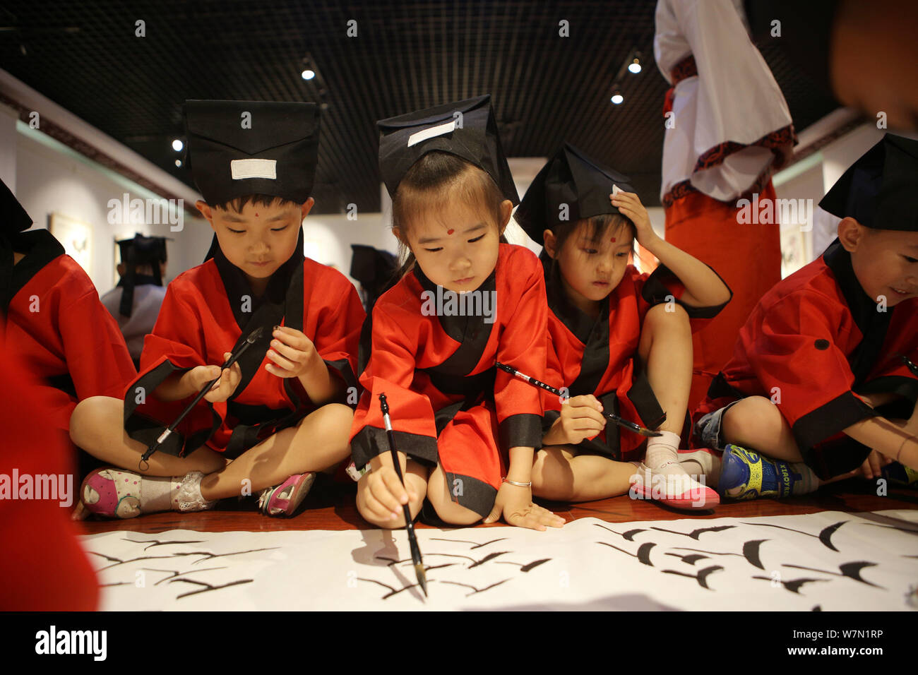 Students write the Chinese character "Ren," meaning "Human" in English ...