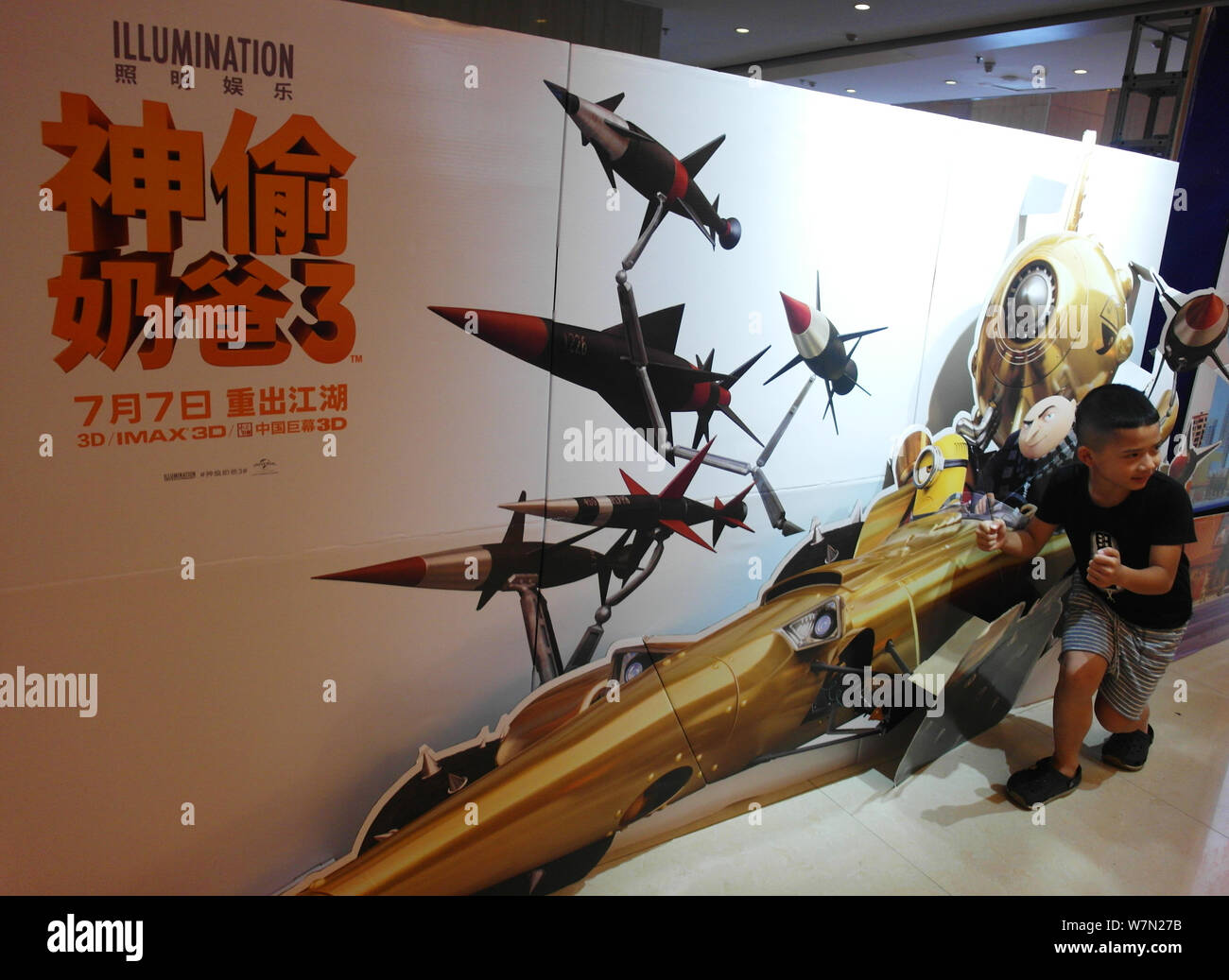 A young boy poses in front of a cut-out of the movie "Despicable Me 3 ...