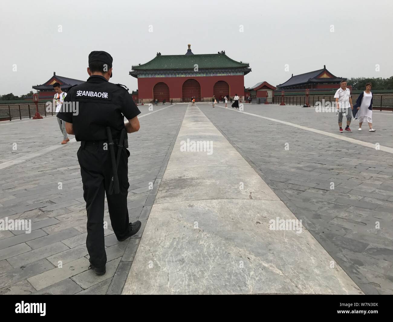 A Chinese security guard walks along the Danbi Bridge with visitors ...