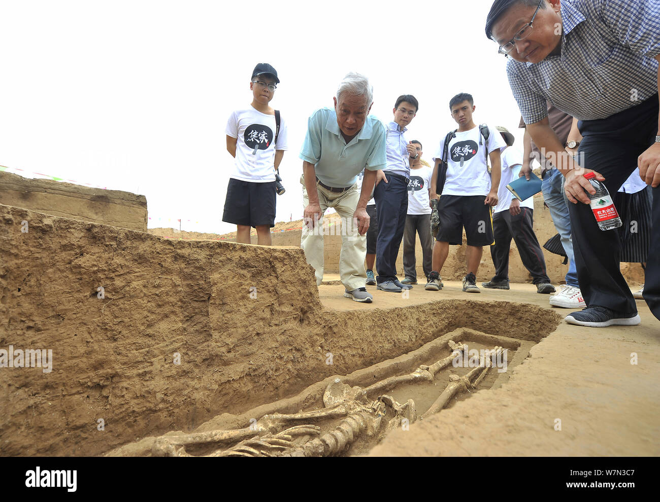 --FILE--Chinese archaeologists look at a skeleton reaching 1.9 meters ...