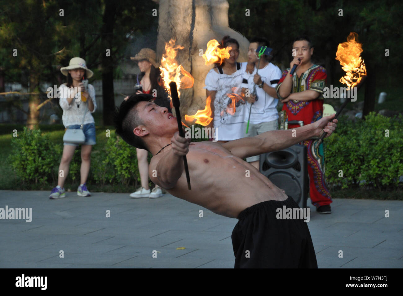 A Chinese artist performs for tourists with fire on Toufu, the first ...