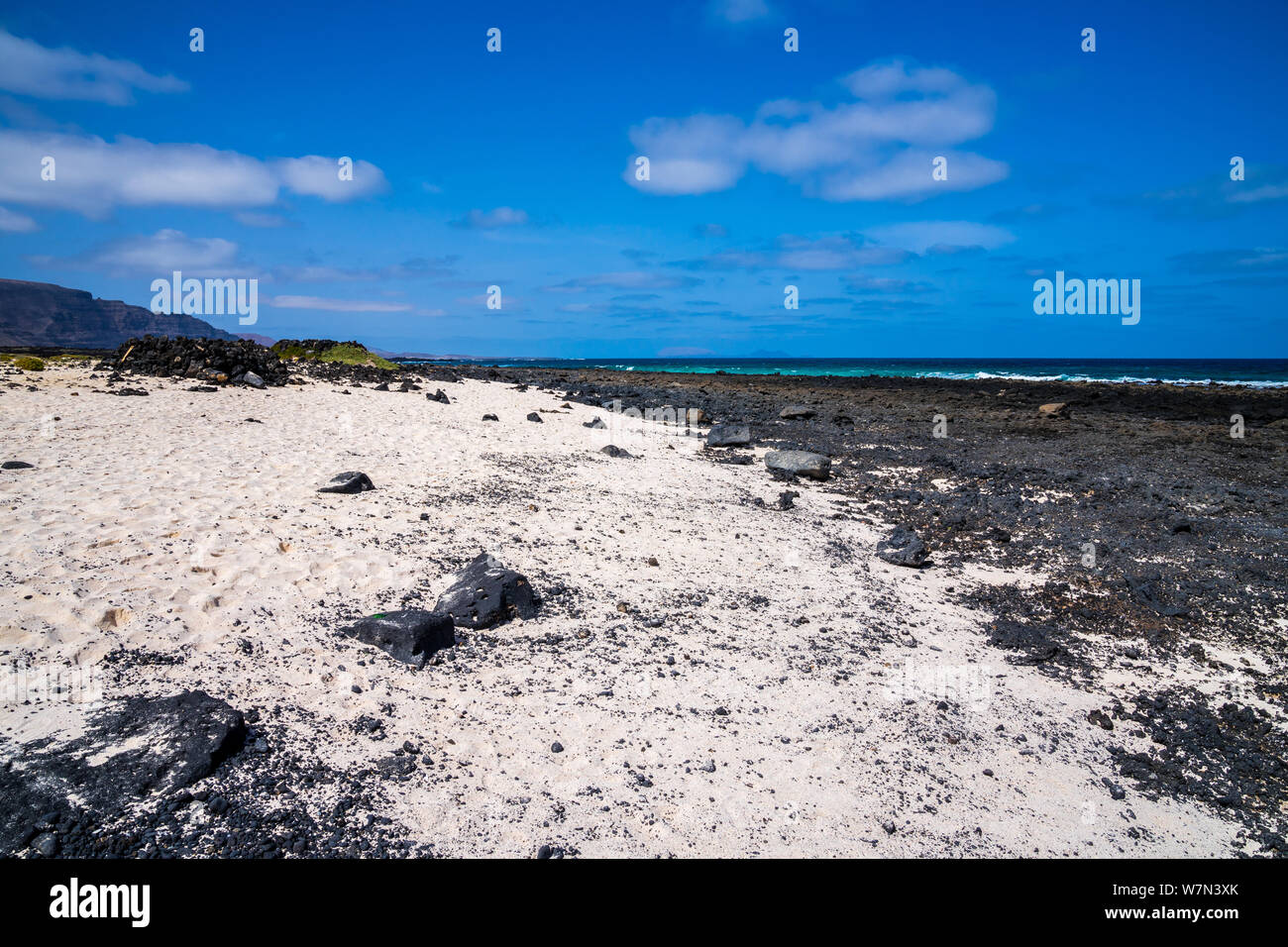 Spain, Lanzarote, White sand beach next to black lava field at ...