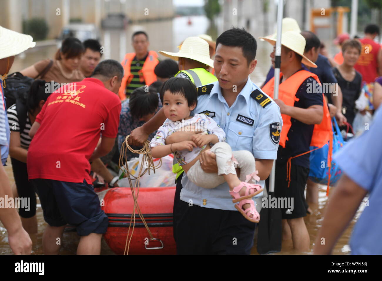 A Chinese rescuer evacuates a young girl from flooded areas caused by ...