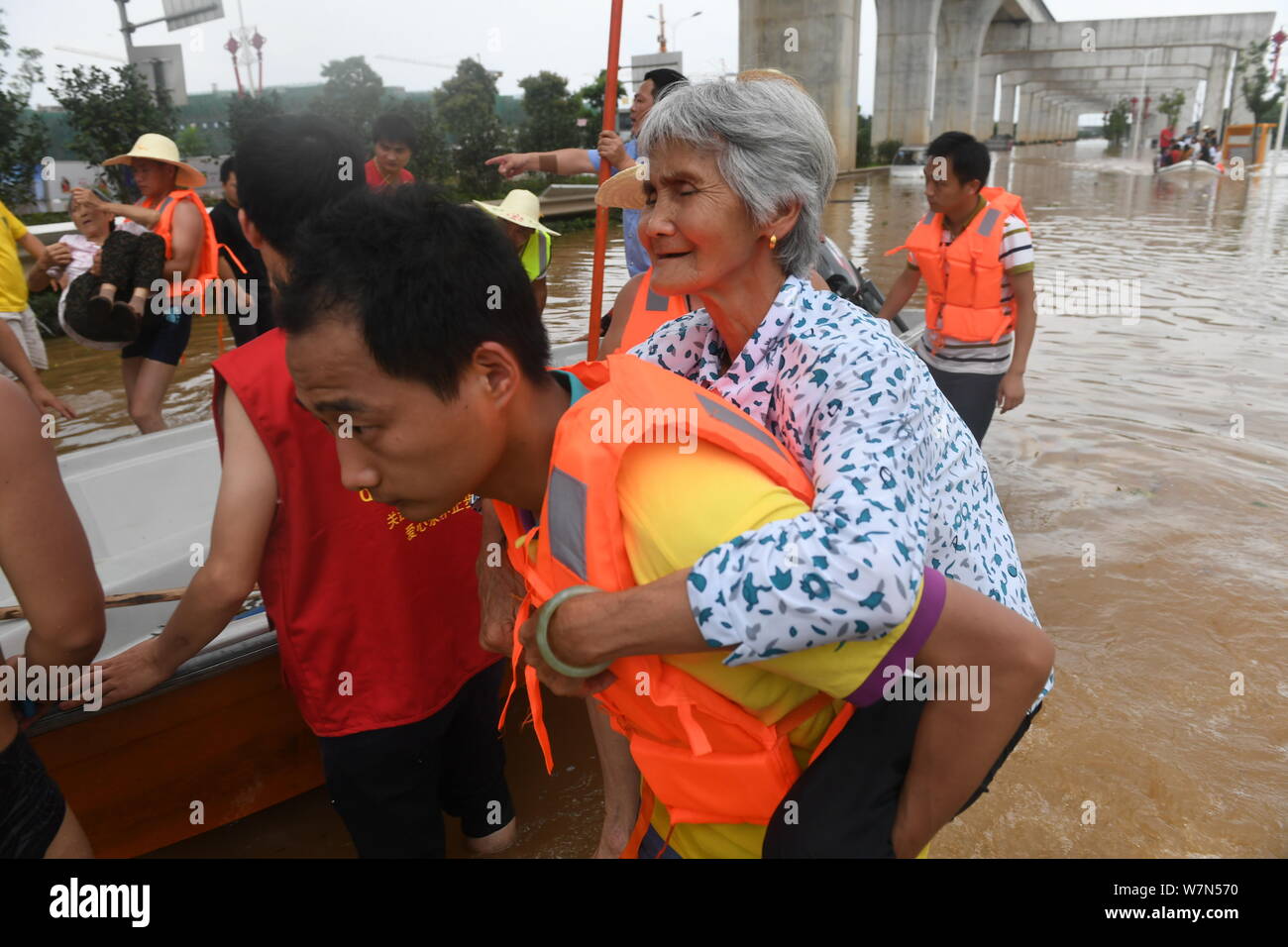 A Chinese rescuer evacuates an elderly woman from flooded areas caused ...