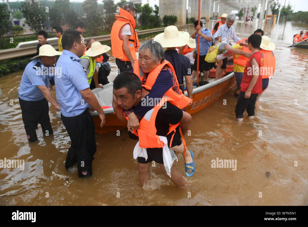 A Chinese rescuer evacuates an elderly woman from flooded areas caused ...