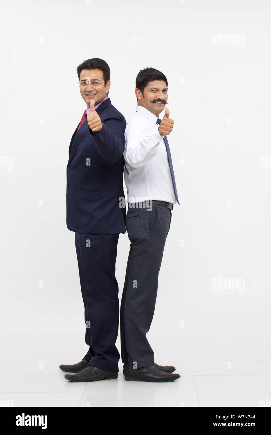 Two business executives standing back to back Stock Photo - Alamy