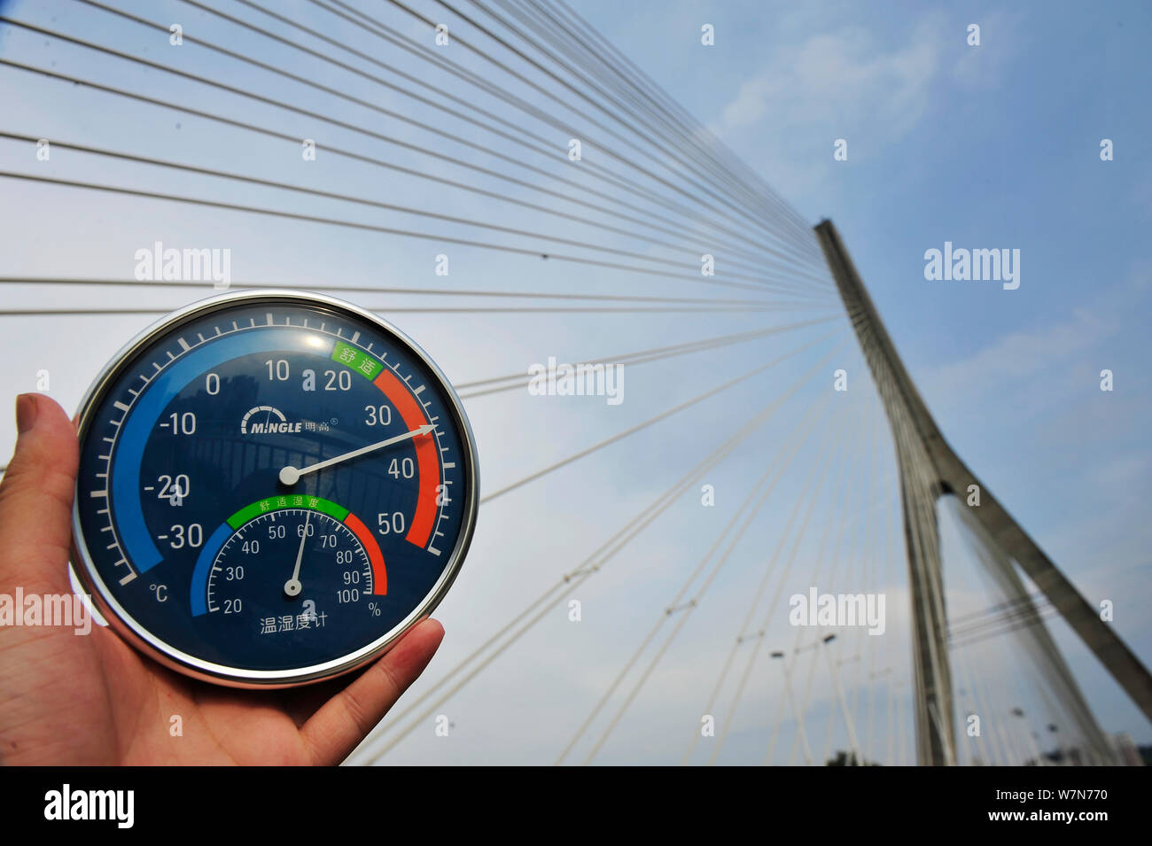 A local resident displays a thermometer showing the current temperature ...