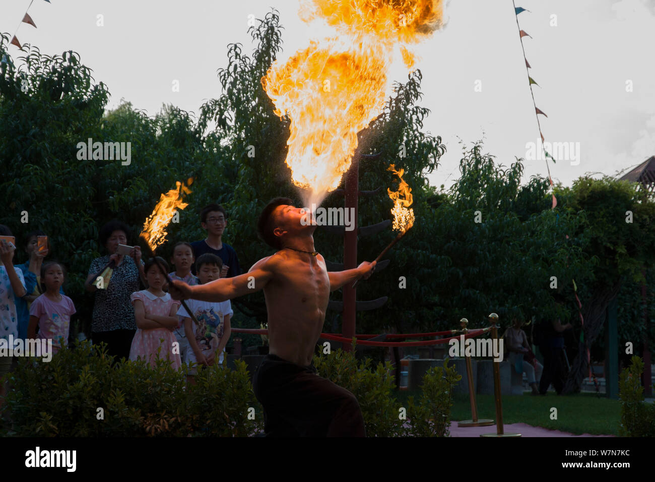 A Chinese artist performs for tourists with fire on Toufu, the first ...