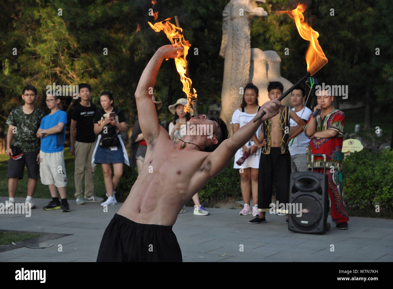 A Chinese artist performs for tourists with fire on Toufu, the first ...