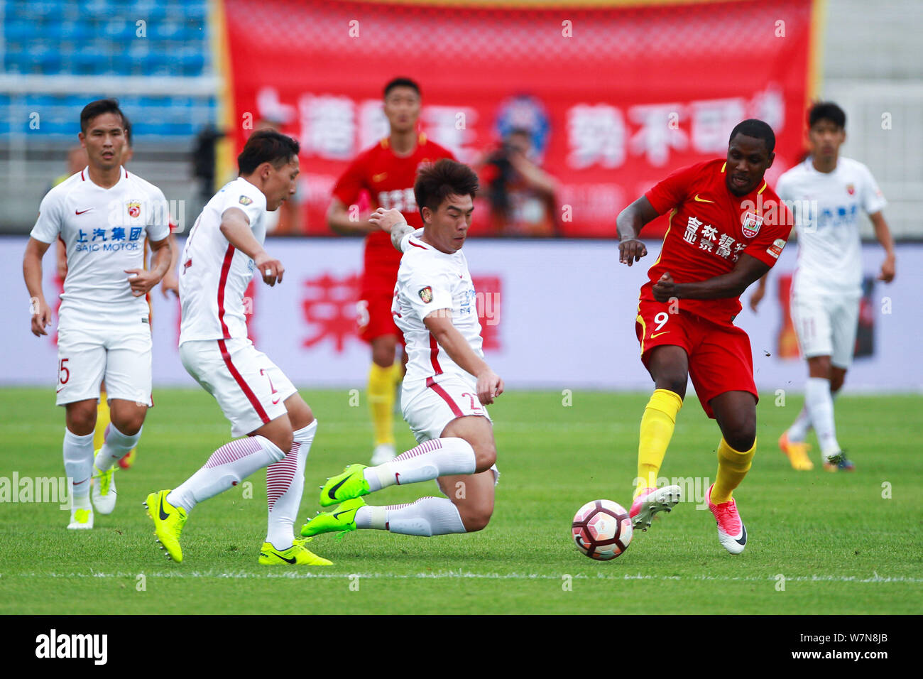 Nigerian football player Odion Ighalo, right, of Changchun Yatai kicks the ball to make a pass ...