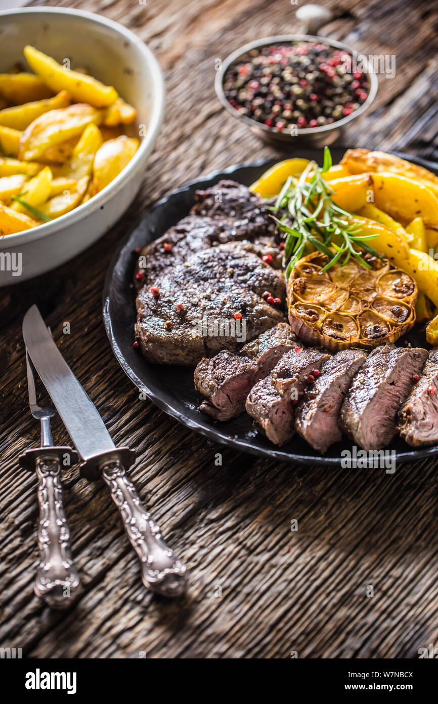Grilled beef Rib Eye steak with garlic american potatoes rosemary salt ...
