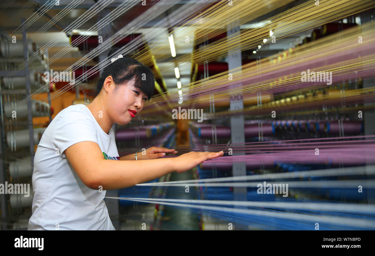 --FILE--A female Chinese worker handles production of yarn at a textile factory in Xinyang ...