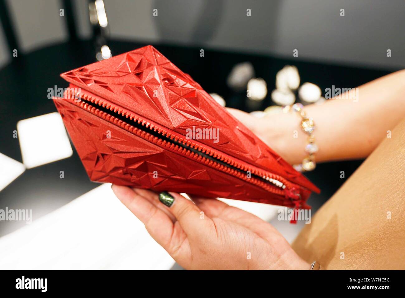 A visitor looks at a 3D-printed wallet at the China 3D-Printing ...