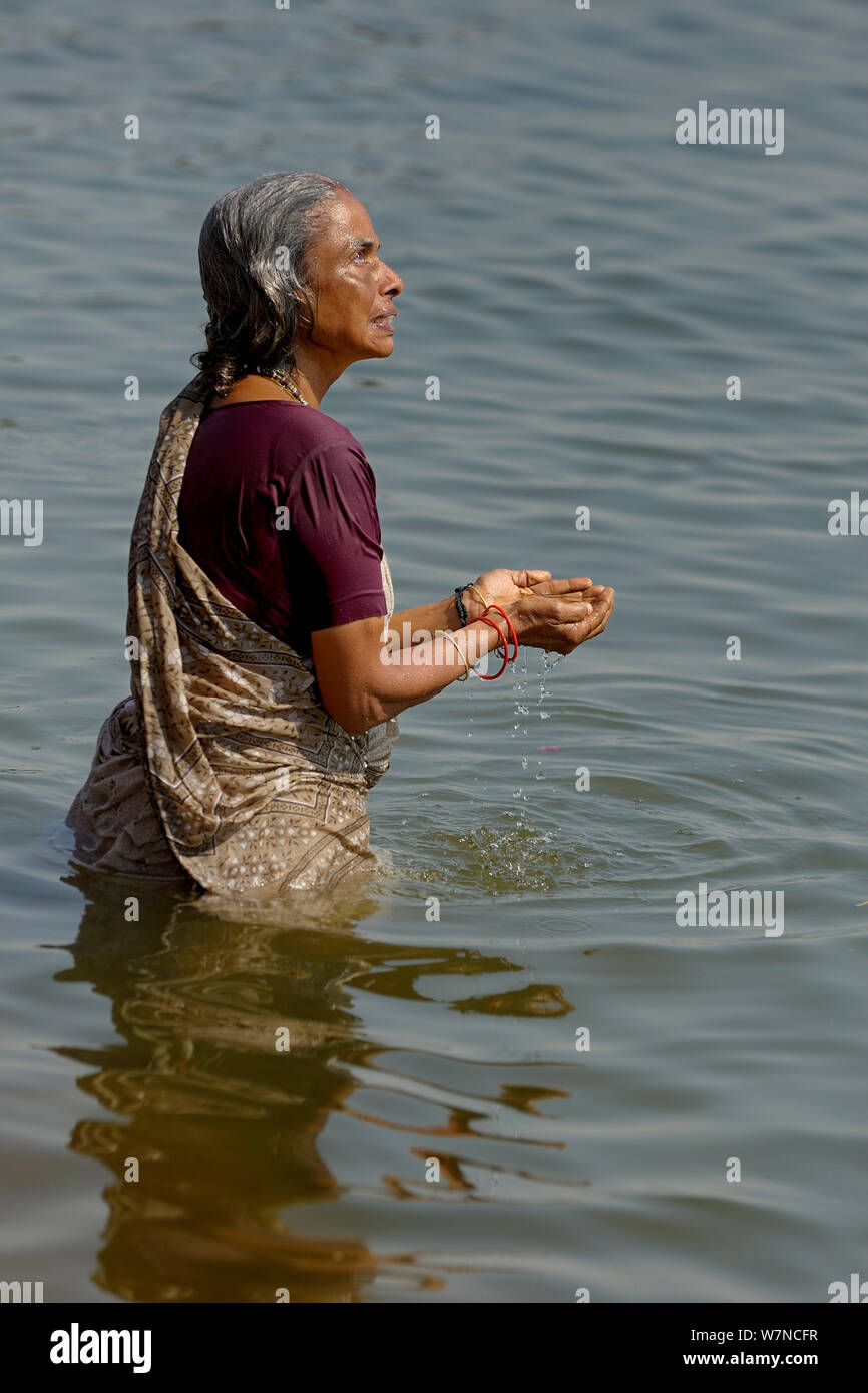 Woman washing in the holy Ganges river, along the famous ghats of ...
