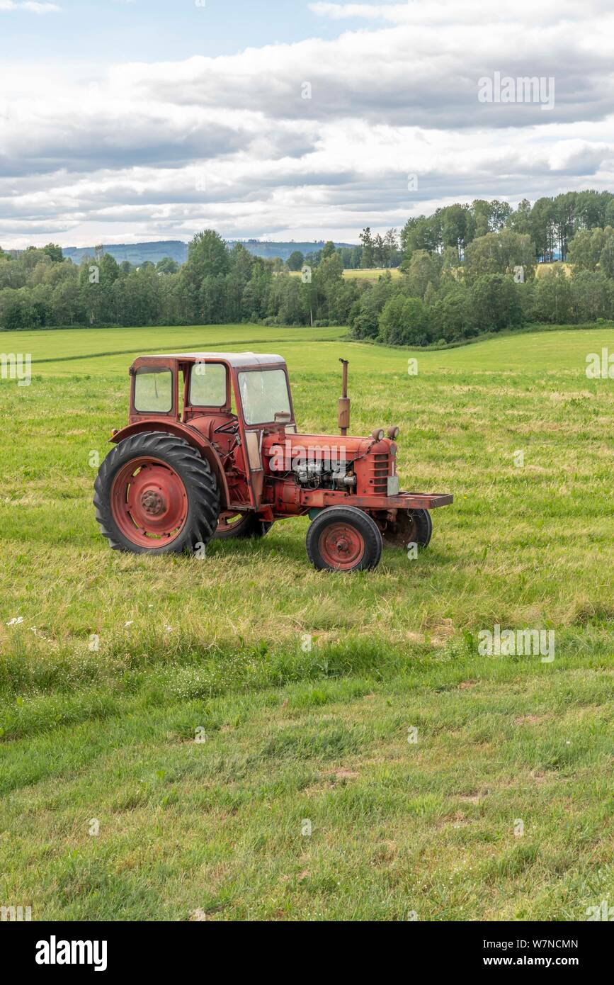 Red tractor in farming landscape Stock Photo - Alamy